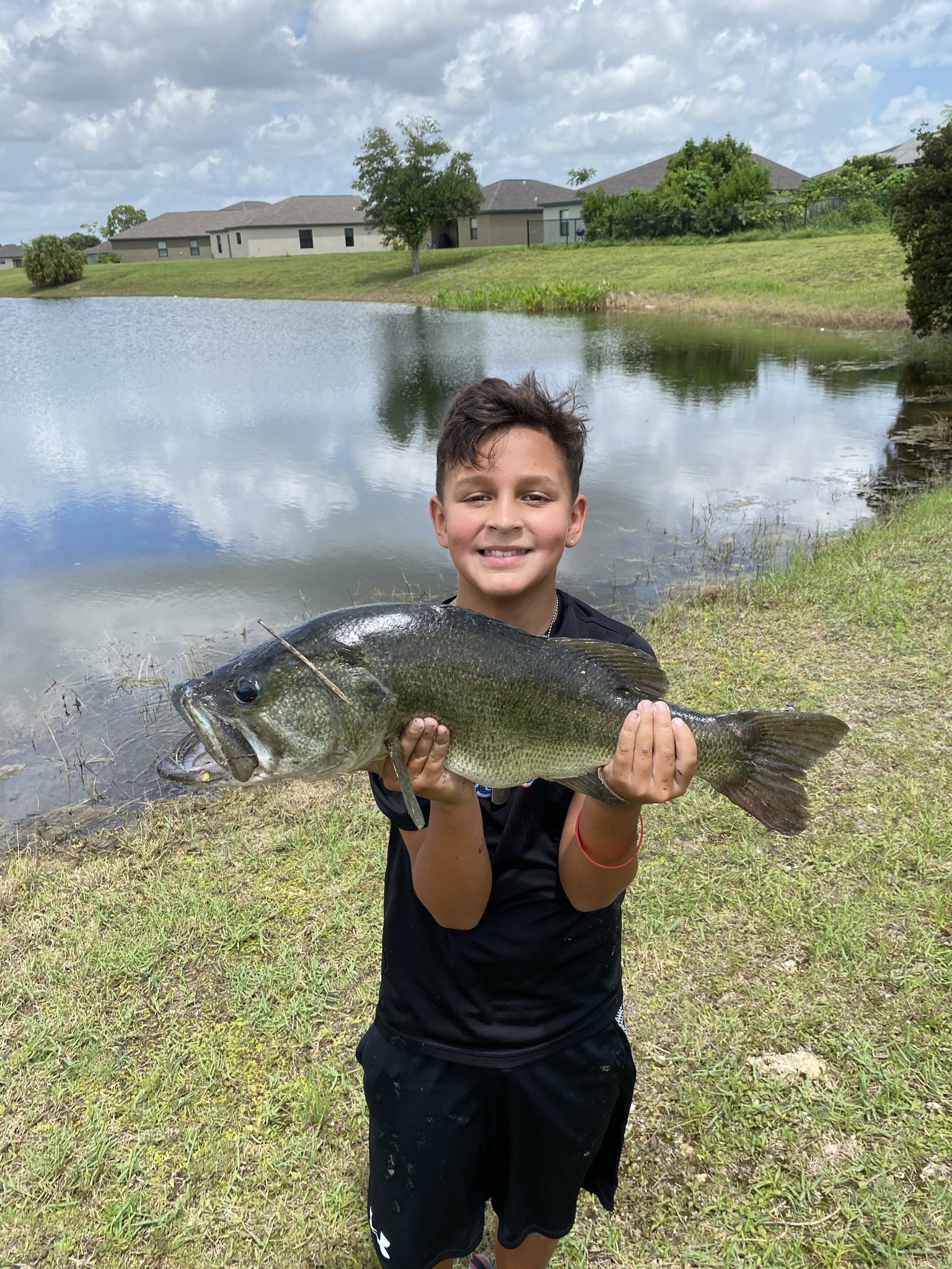 Little man catching a bass - Coastal Angler & The Angler Magazine
